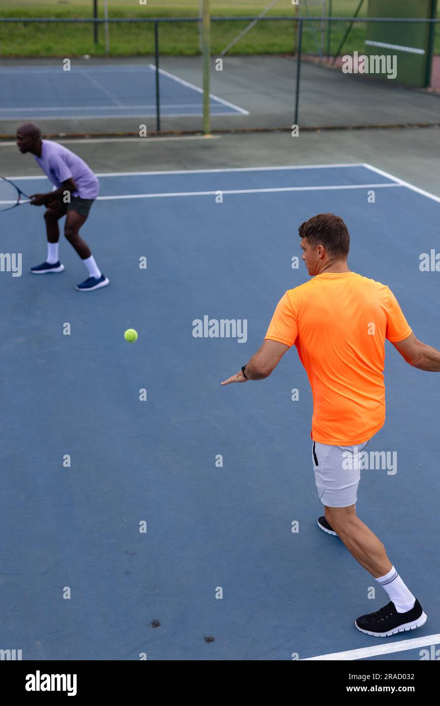 Divers joueurs de tennis masculins jouant en double sur le court ...