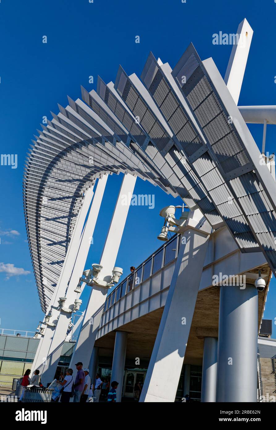 Blanc brillant contre un ciel bleu, une arche en panneau d'acier s'élève au-dessus de la rue ...