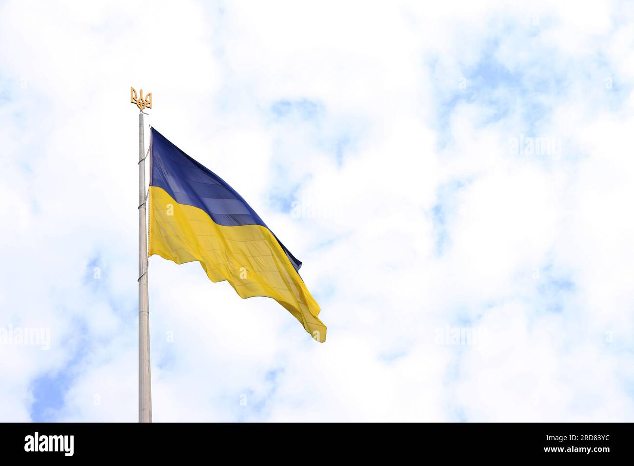 Le drapeau et les armoiries de l'Ukraine sur un mât de drapeau contre ...