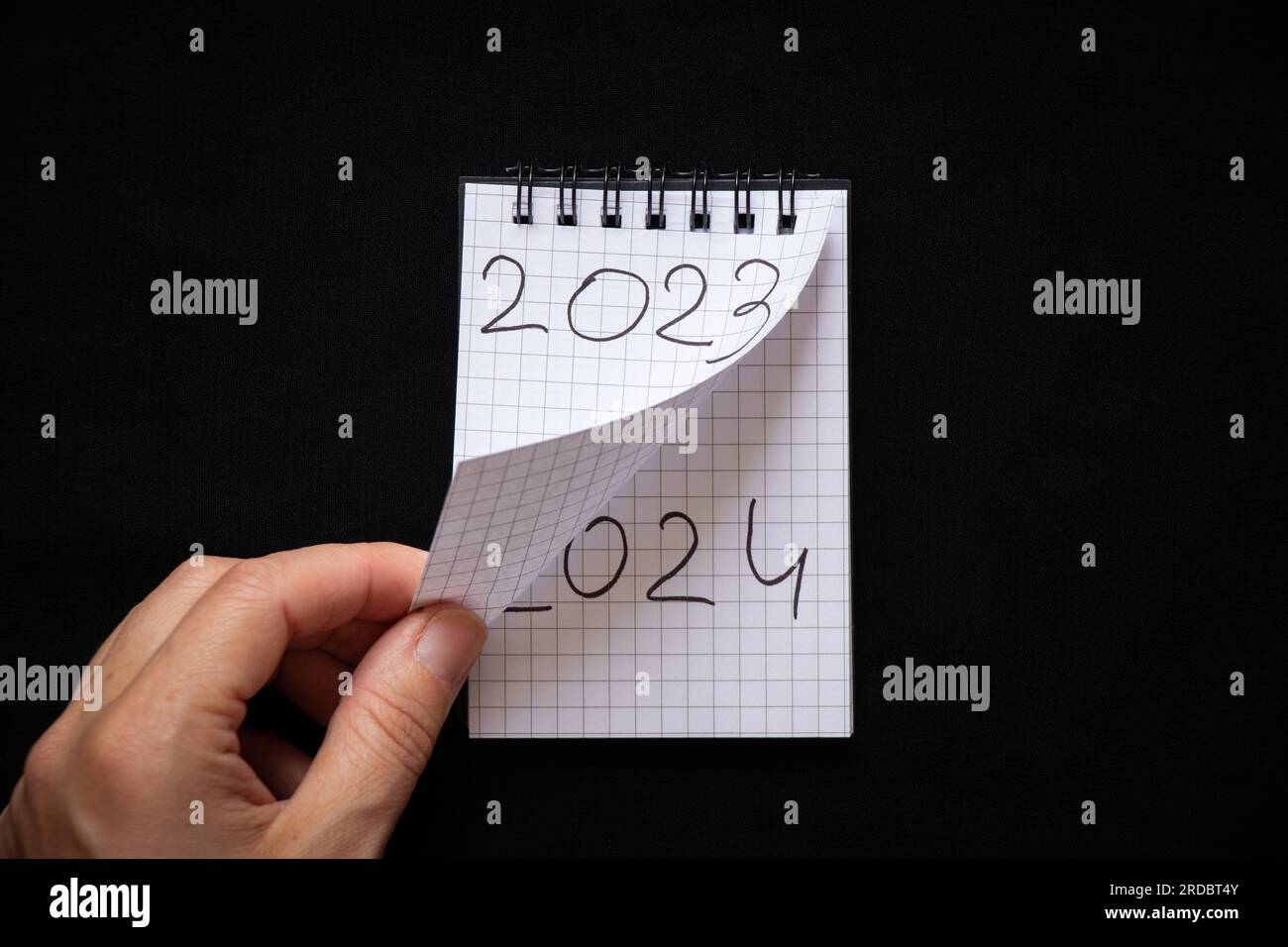 Bloc-notes avec le texte 2023 et 2024 et la main tourne la page du bloc ... Bloc-notes avec le texte 2023 et 2024 et la main tourne la page du bloc ...