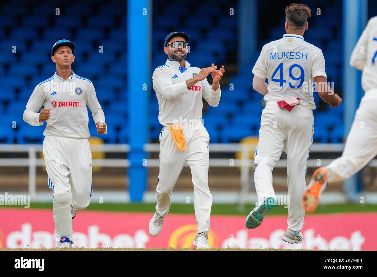 India's Virat Kohli, center, celebrates with bowler India's Mukesh ...