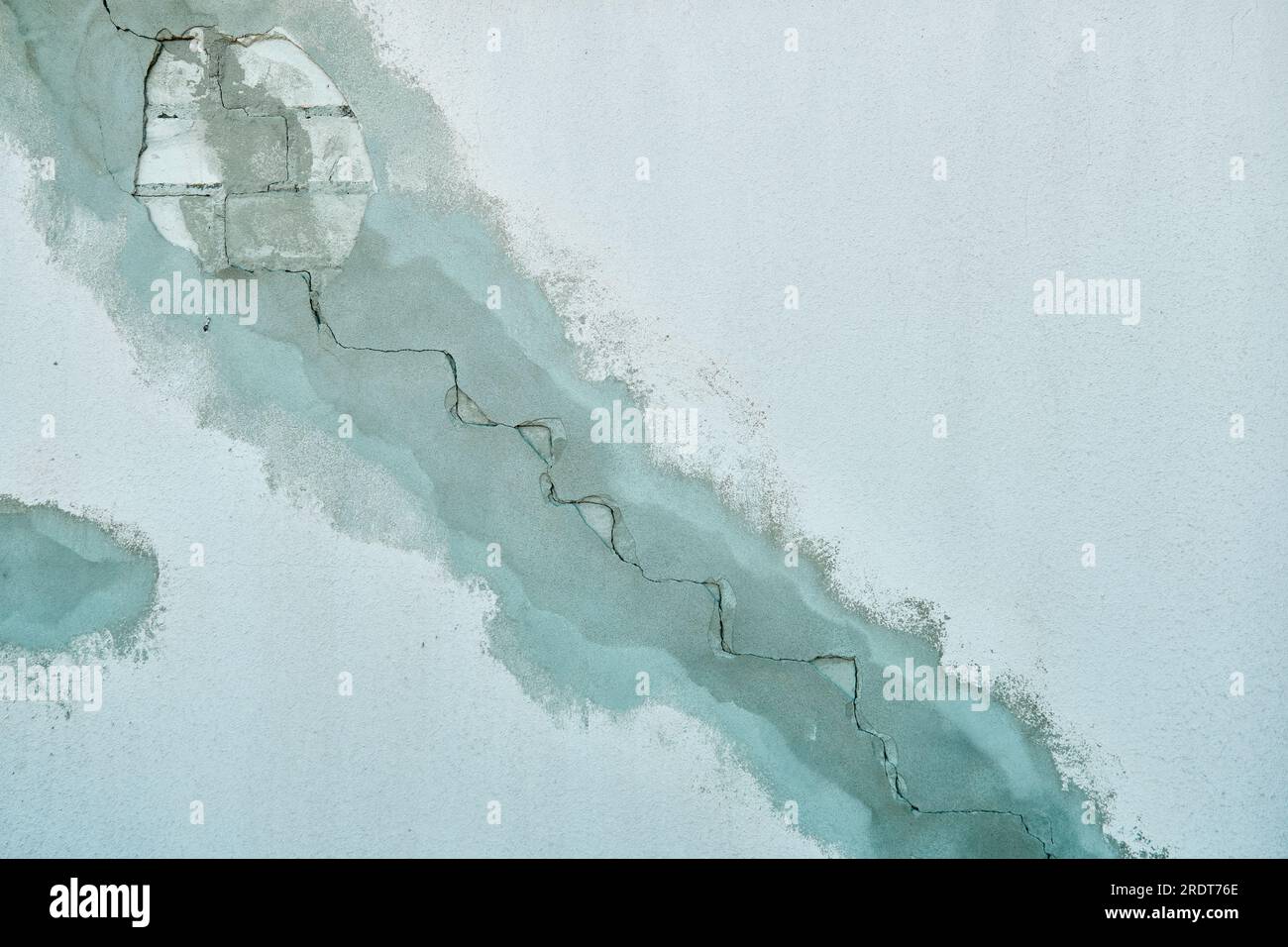 Mur de béton avec fissure descendant réparé avec du mastic de patching ...