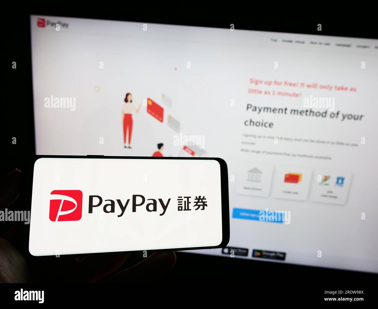 Personne tenant le téléphone mobile avec le logo de la société de paiement japonaise PayPay ...