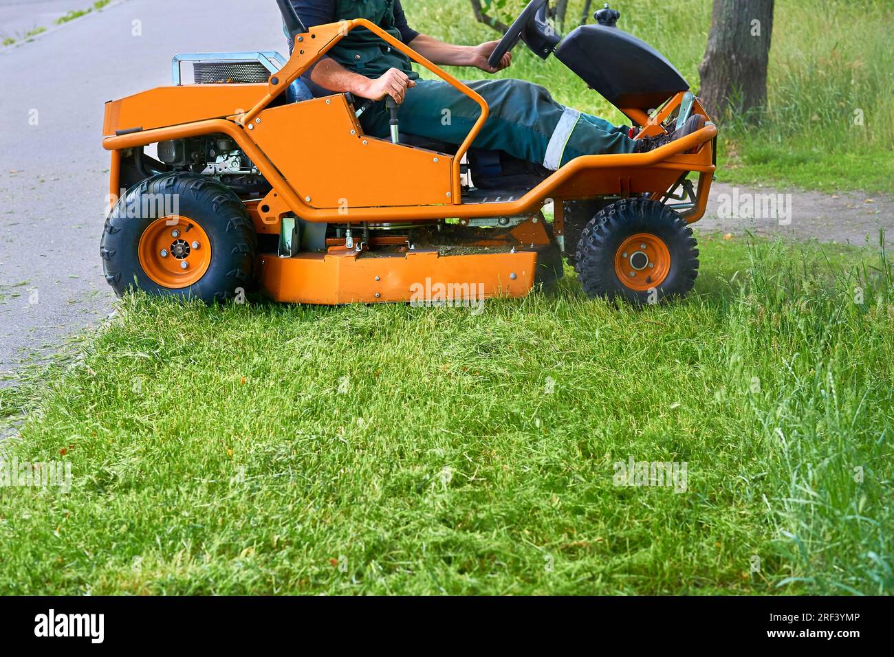 Coupe professionnelle de l'herbe sur les pelouses avec une mini tondeuse à gazon pour tracteur ...