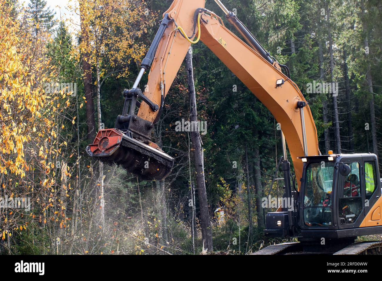La déchiqueteuse à bois coupe le bois sur le côté de la route à l'aide ...