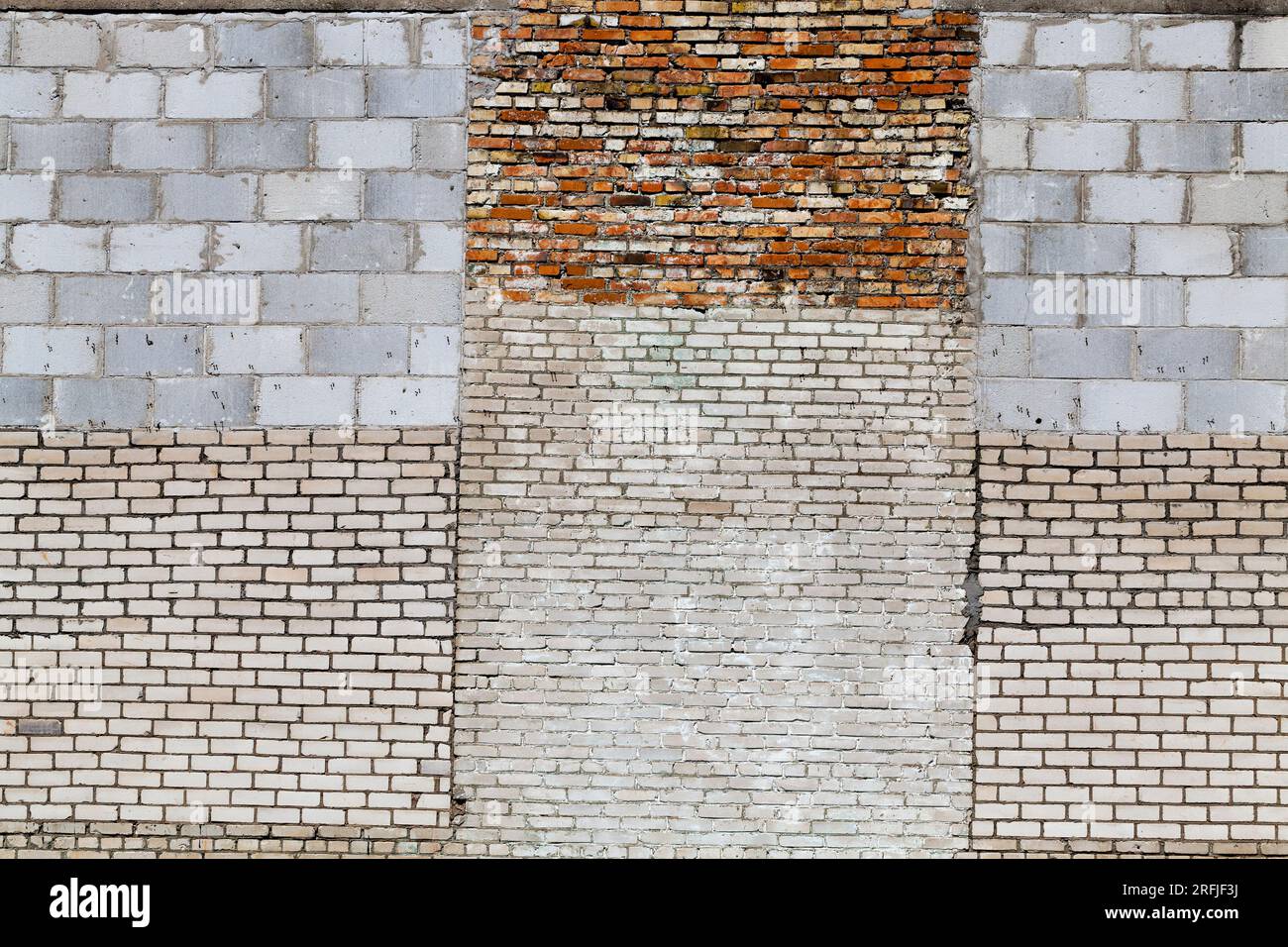 le mur du bâtiment est fait de différentes qualités et types de briques ...