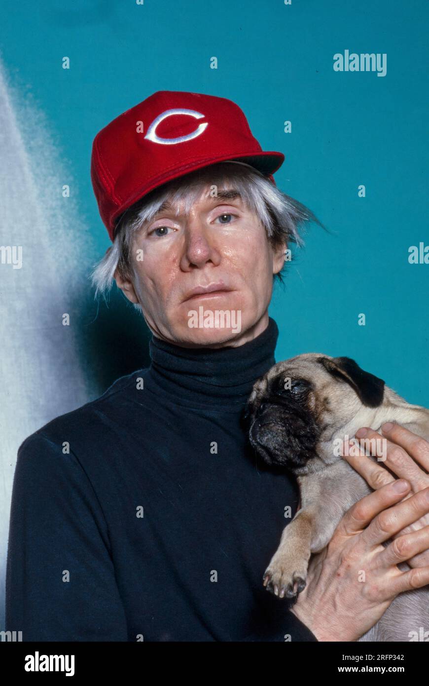 Andy Warhol pose en portant une casquette de baseball Cincinnati Reds ...