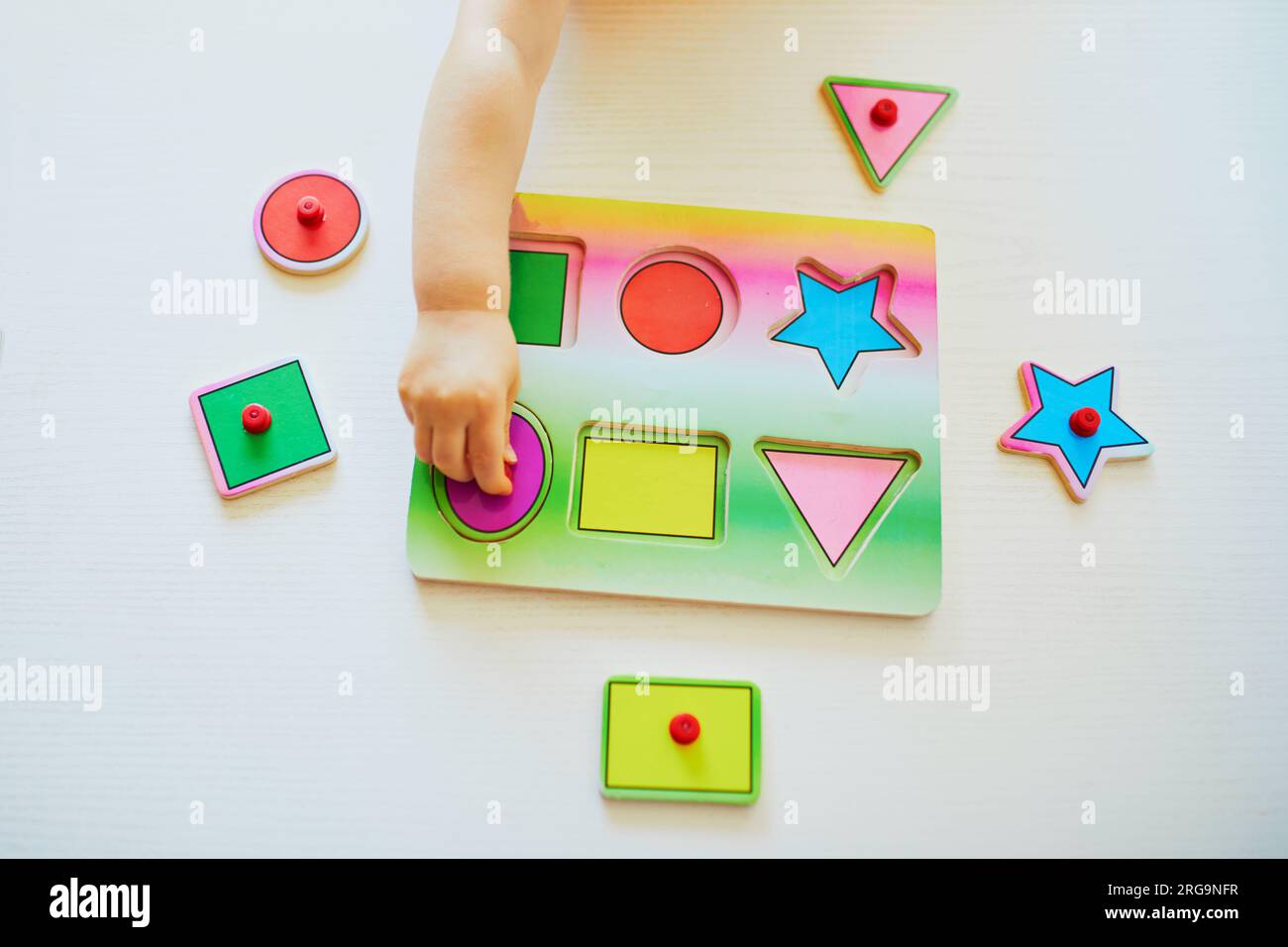 Petite fille ou garçon faisant puzzle en bois. Apprentissage des formes ...