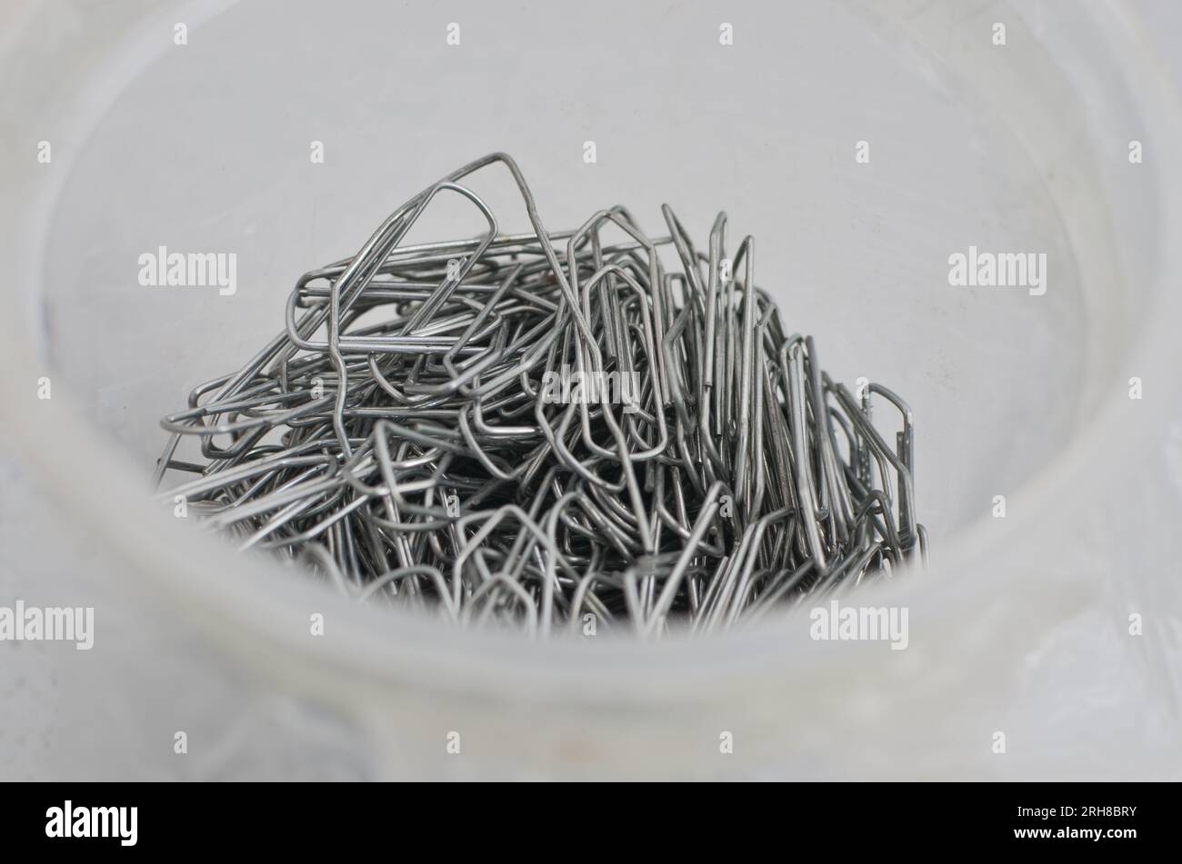 Gros plan de trombones sur une surface légère, idéal pour les concepts de bureau et de papeterie ...