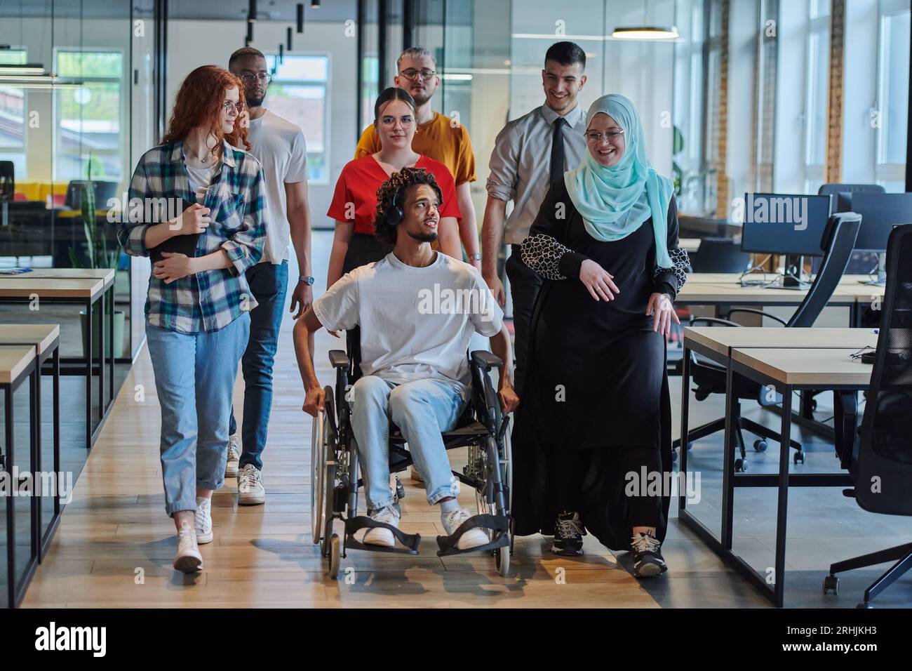 Un groupe diversifié de jeunes gens d'affaires marchant dans un couloir ...