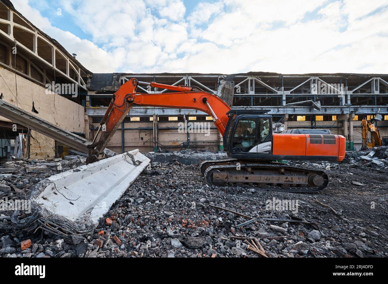 La pelle hydraulique enlève la poutre en béton sur le chantier de ...