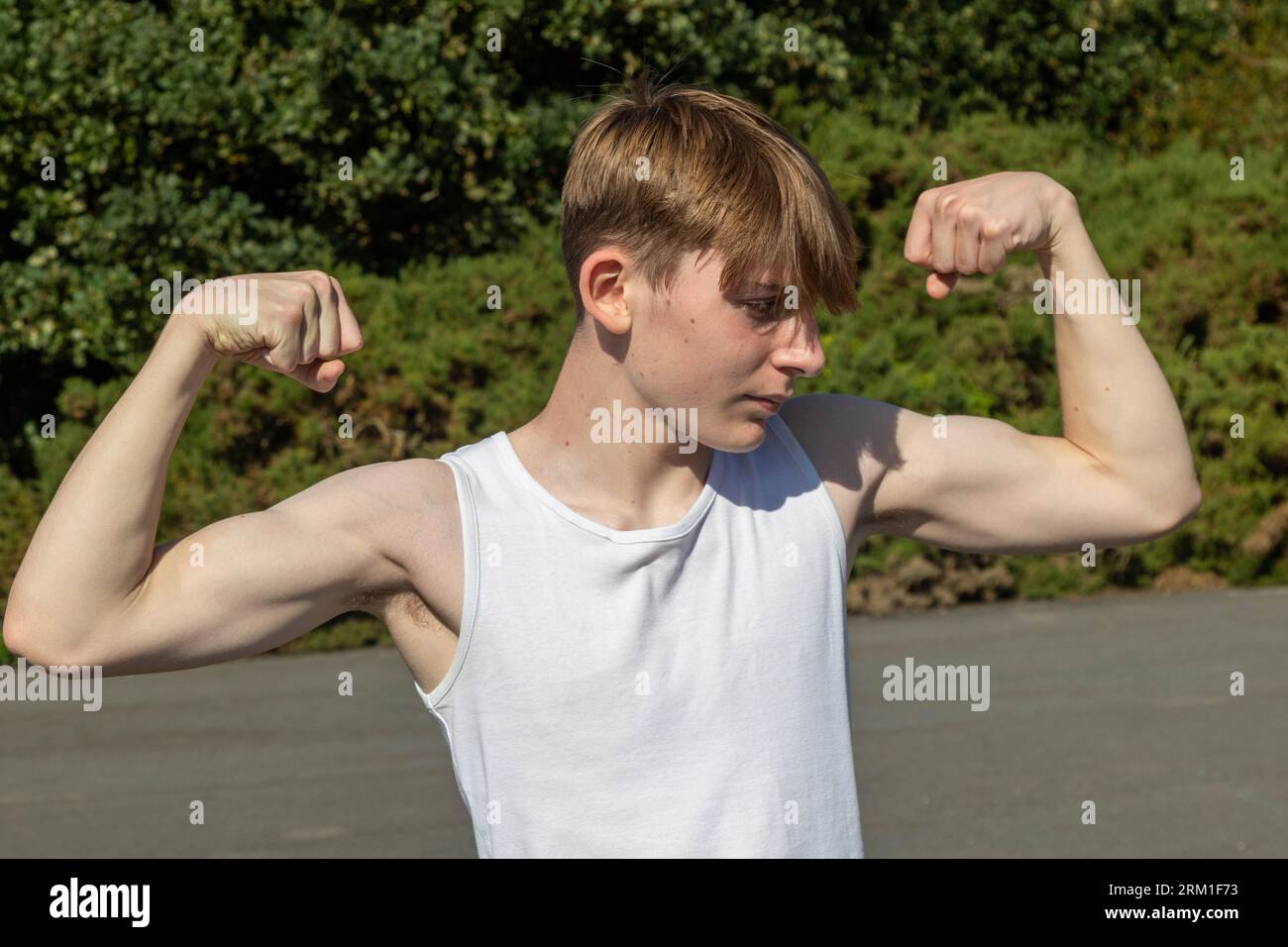 Adolescent en forme et sportif fléchissant ses deux biceps Photo Stock ...