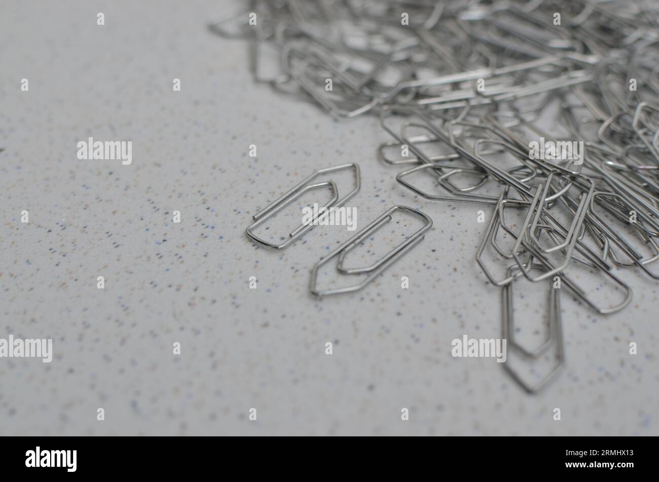 Gros plan de trombones sur une surface légère, idéal pour les concepts de bureau et de papeterie ...