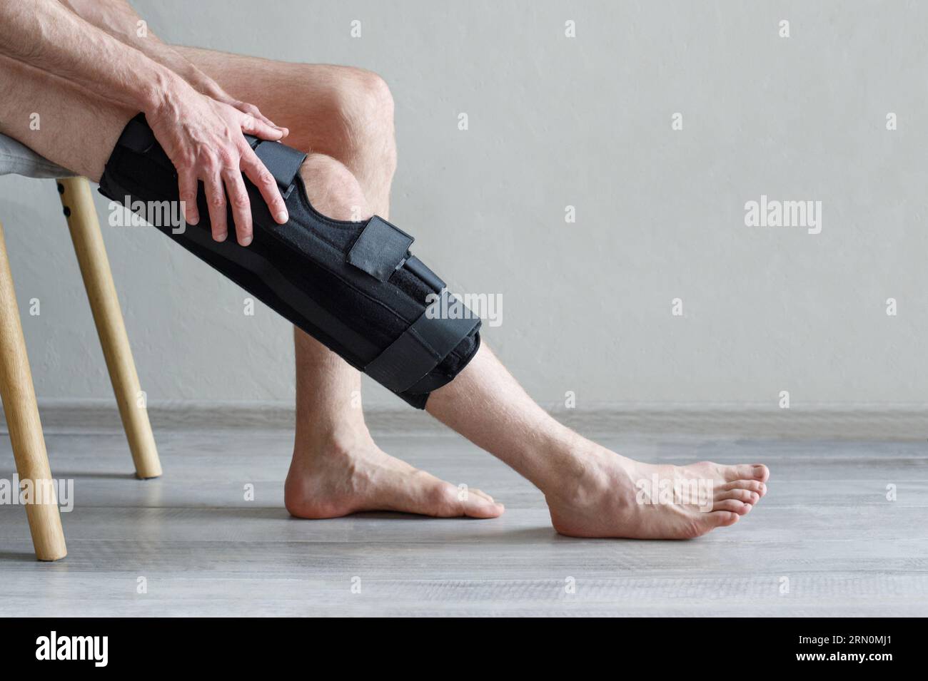 Genouillère sur la jambe masculine sur fond gris. Orthose anatomique ...