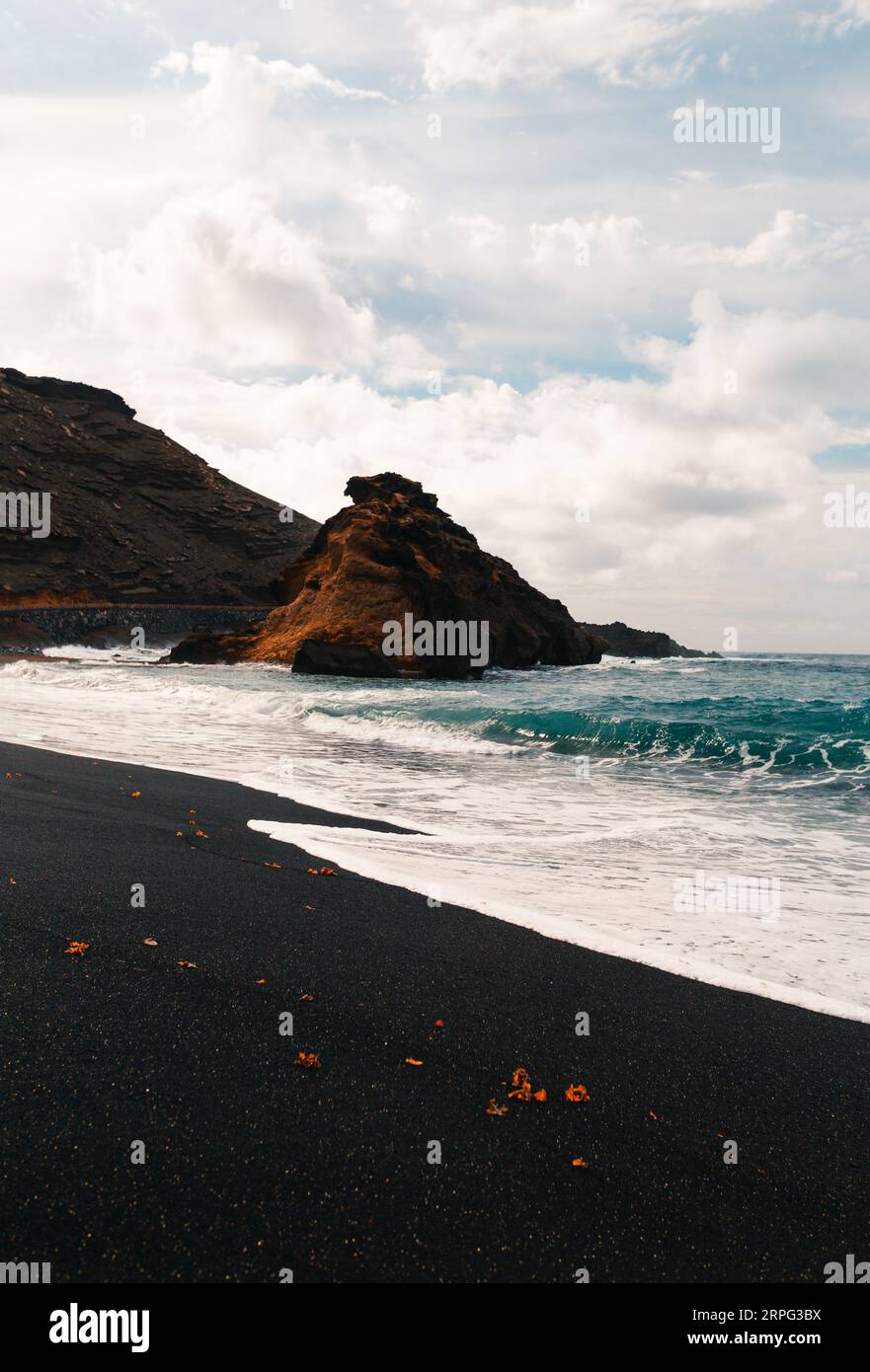 Photo verticale de la plage de sable noir El Golfo dans l'île ...