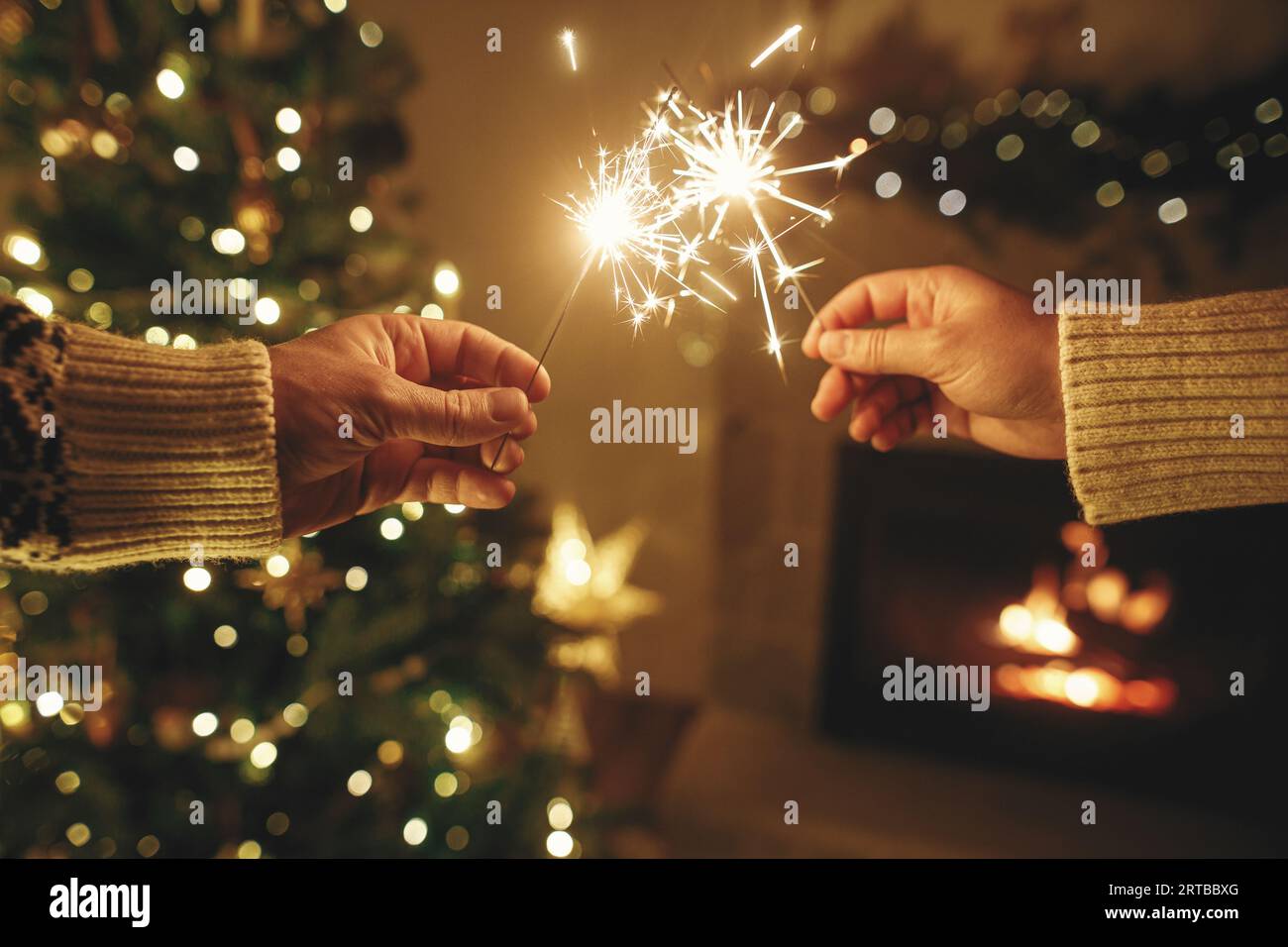 Bonne année ! Mains tenant des feux d'artifice brûlants contre la ...