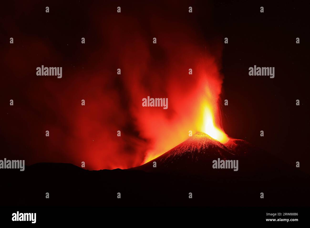 Etna dans une éruption de lave nocturne avec cratère de silhouette rétro-éclairé et de grandes ...