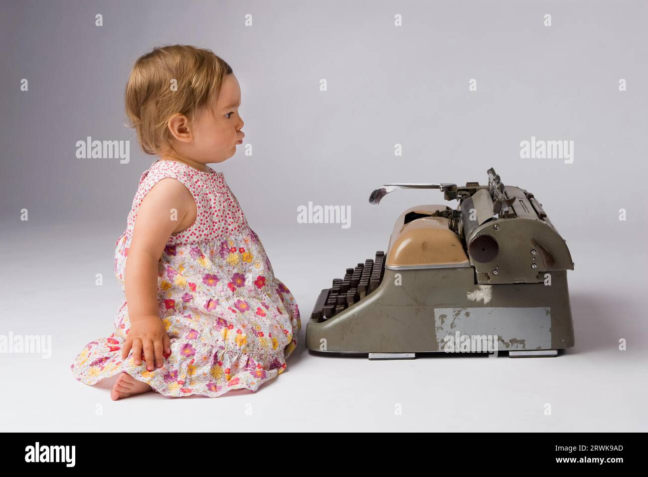 Une expression d'une mignonne petite fille d'un an assis devant une ... Une expression d'une mignonne petite fille d'un an assis devant une ...