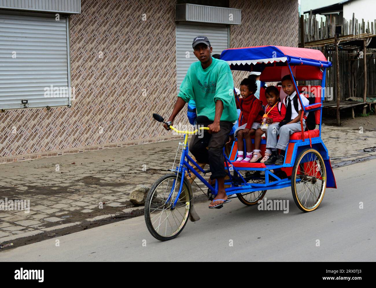 Des enfants malgaches de l'école primaire vont à l'école dans un pousse ...