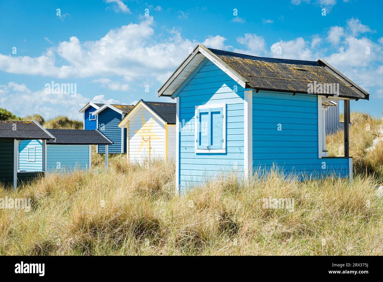 Cabanes en bois colorées balayées par le vent dans les dunes de sable ...