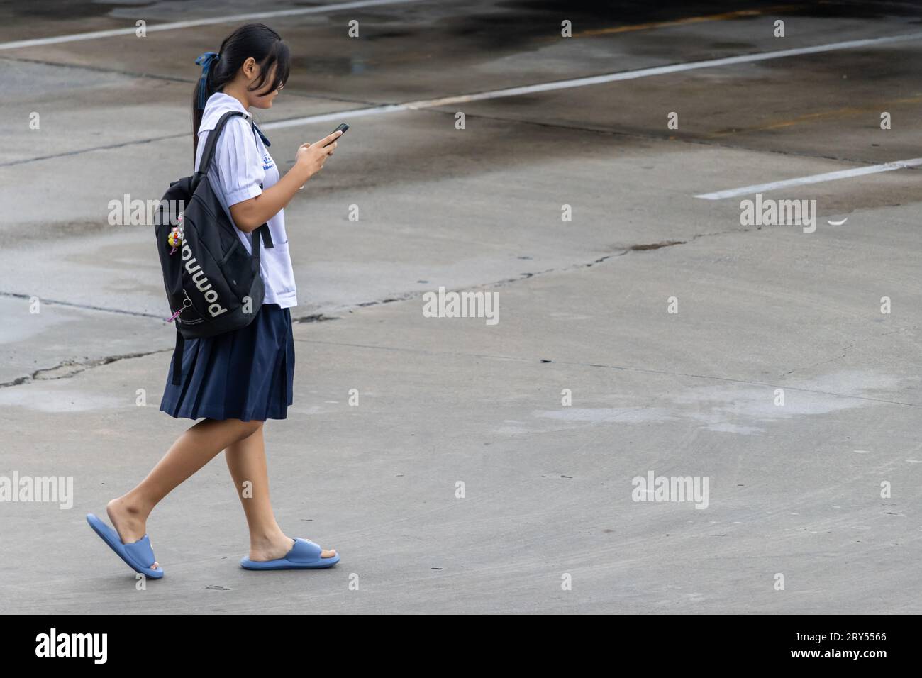 SAMUT PRAKAN, THAÏLANDE, septembre 20 2023, Une fille en uniforme scolaire marche dans la rue ...