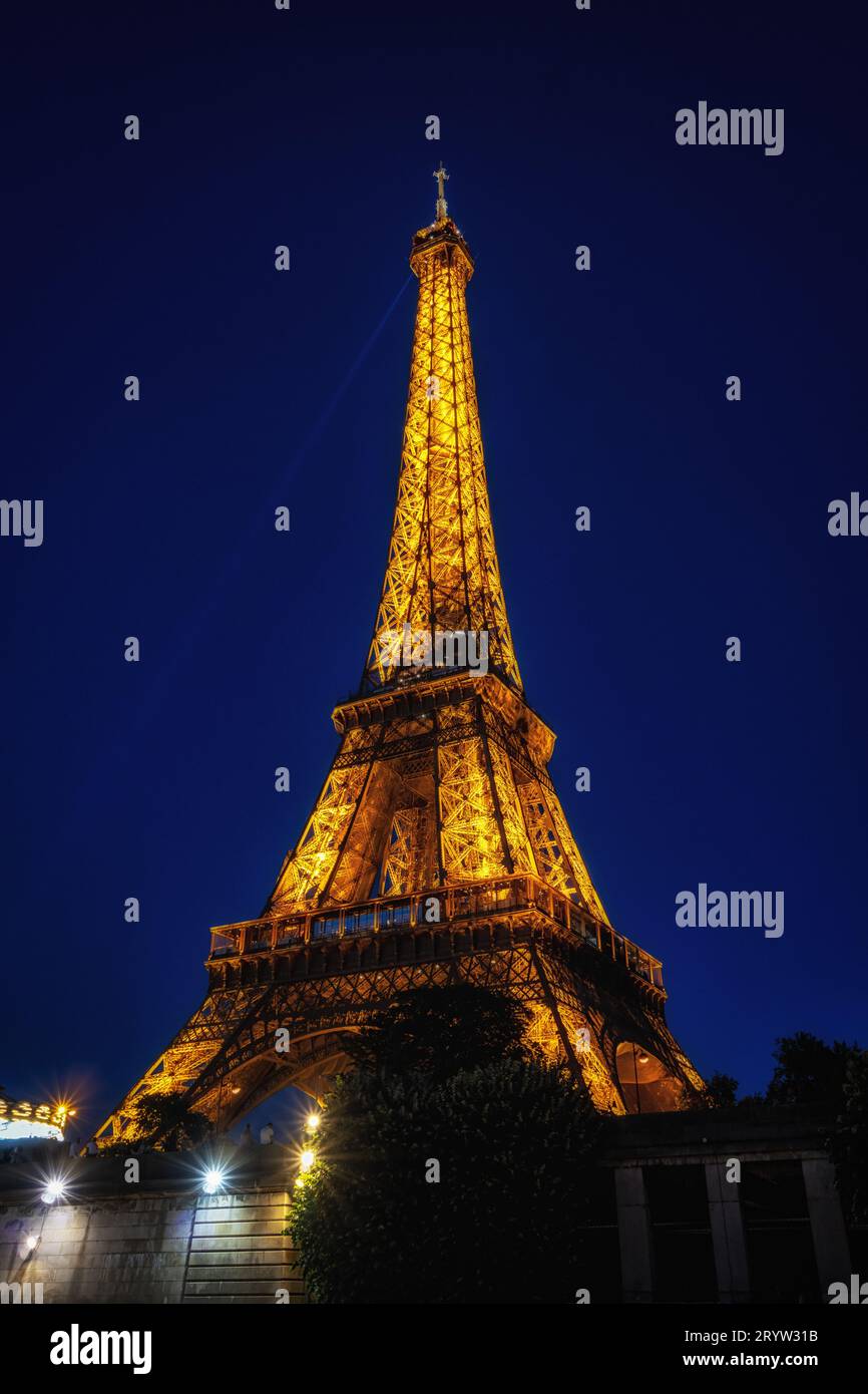 Prise de vue rapprochée de la Tour Eiffel la nuit illuminée. Monument célèbre à Paris, France ...