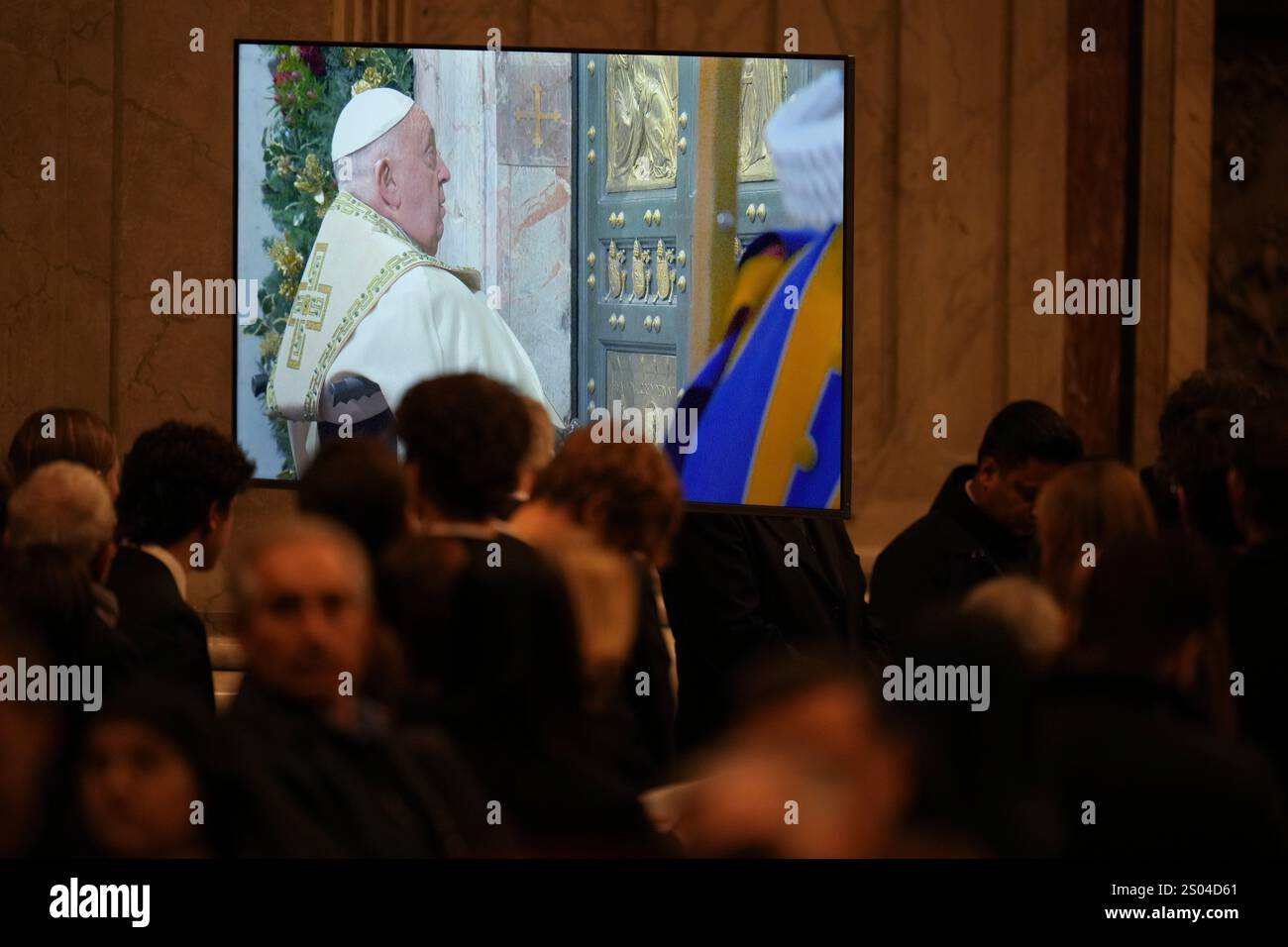 A giant monitor shows Pope Francis pausing before opening the holy door ...
