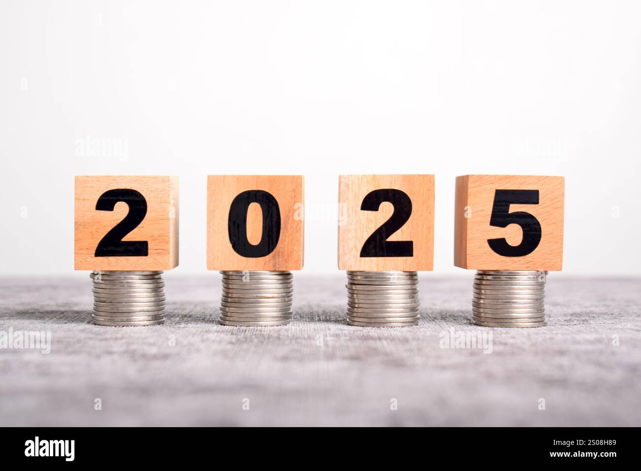 Début du nouvel an 2025. 2025 blocs de cube en bois avec pile de pièces ...