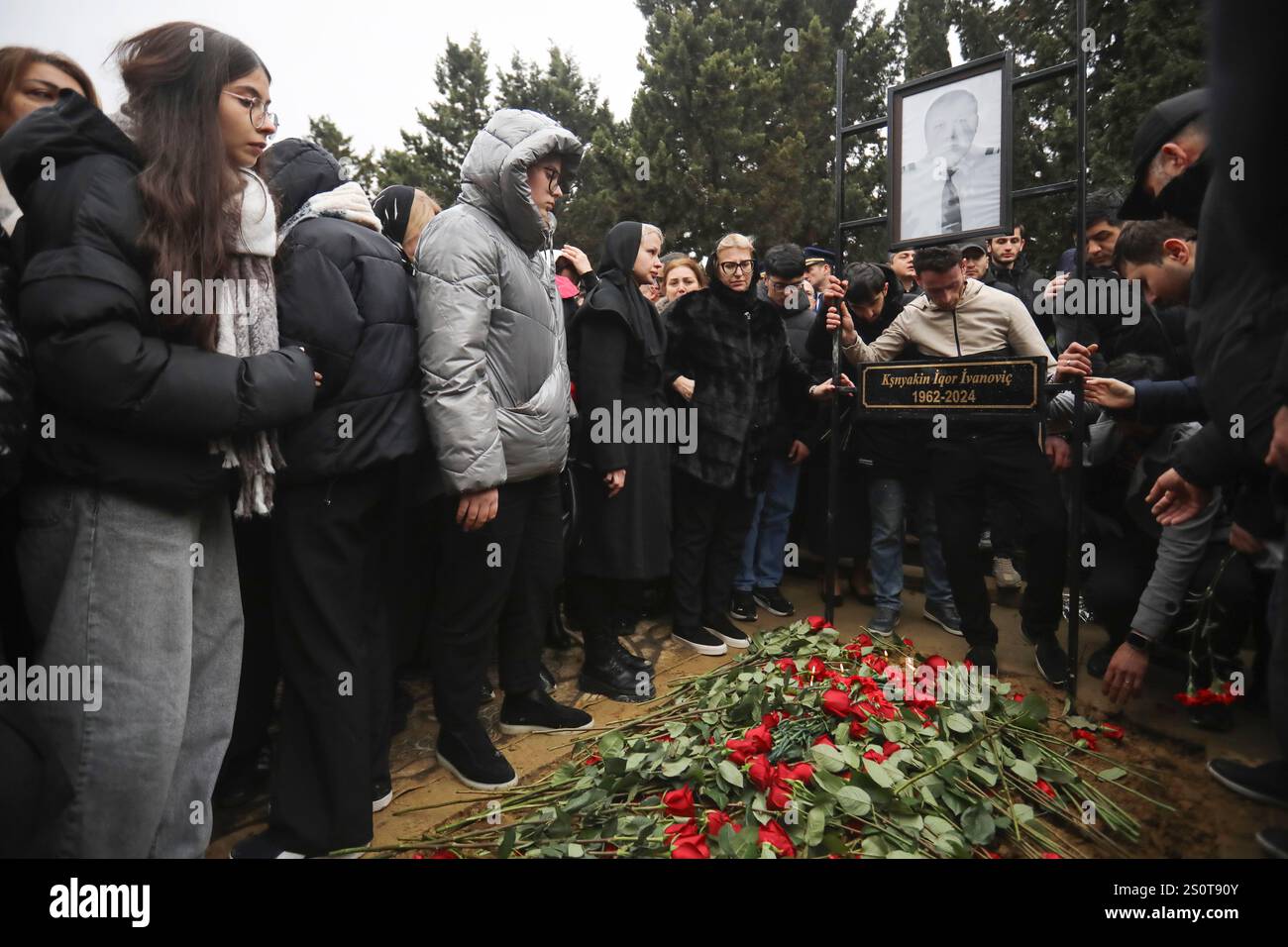 People stand at the grave of pilot in command Igor Kshnyakin during a ...