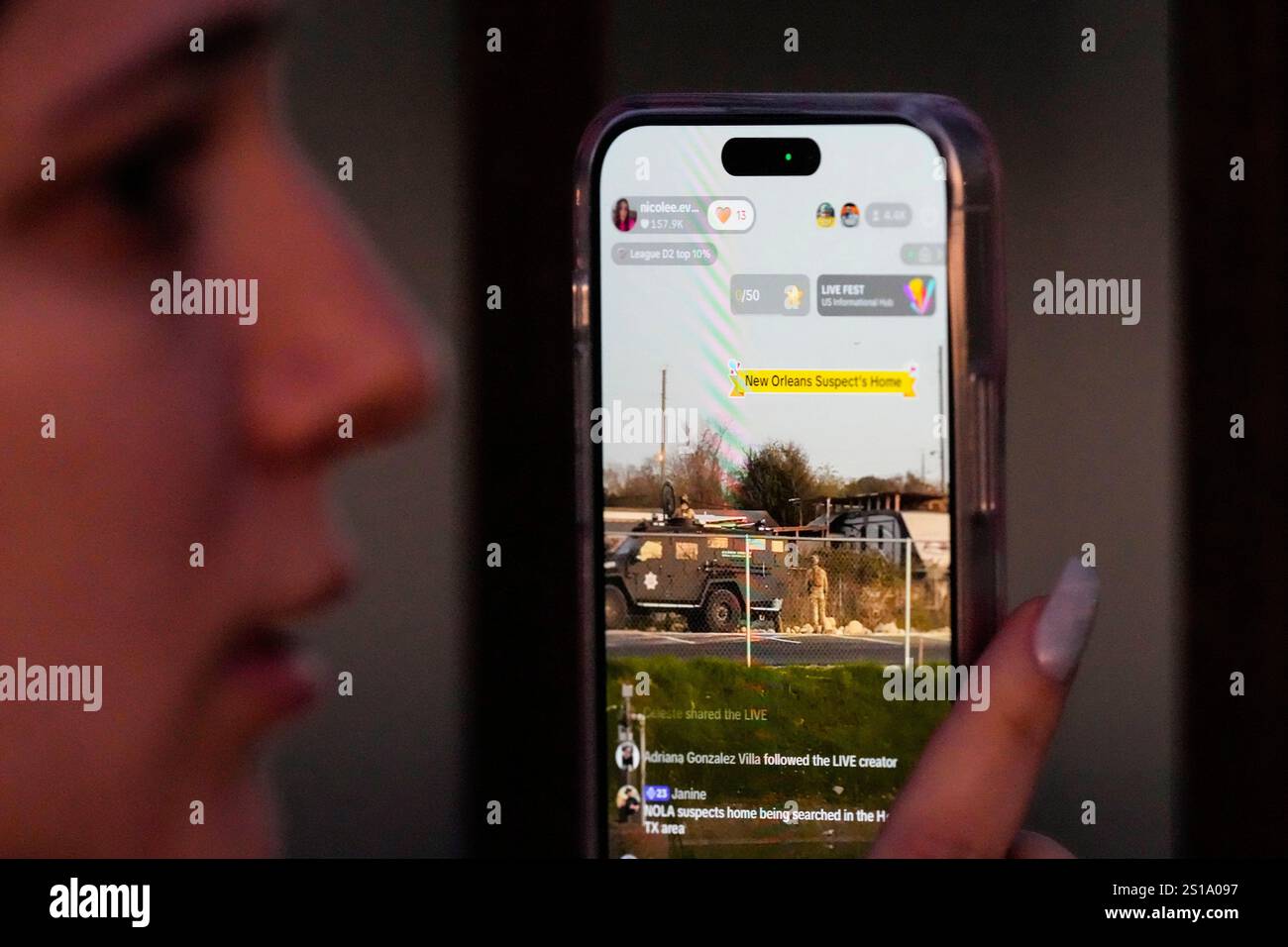 A woman uses her phone to record the scene where a police investigation ...