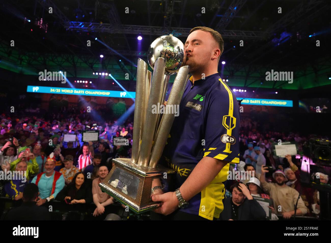 Luke Littler of England kisses the trophy after winning the final ...