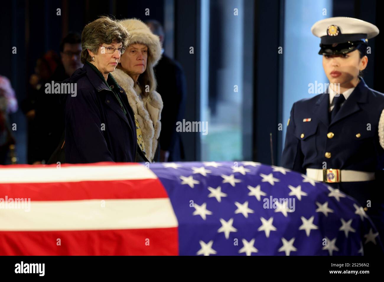 Members of the joint services military honor guard stand by the casket bearing the remains of ...