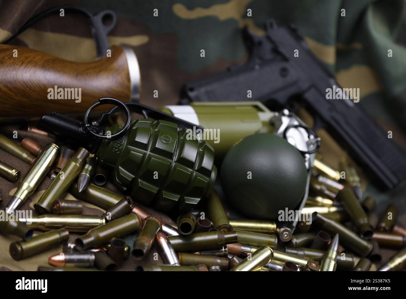 Différents types de munitions et de grenades sur un fond de camouflage ...