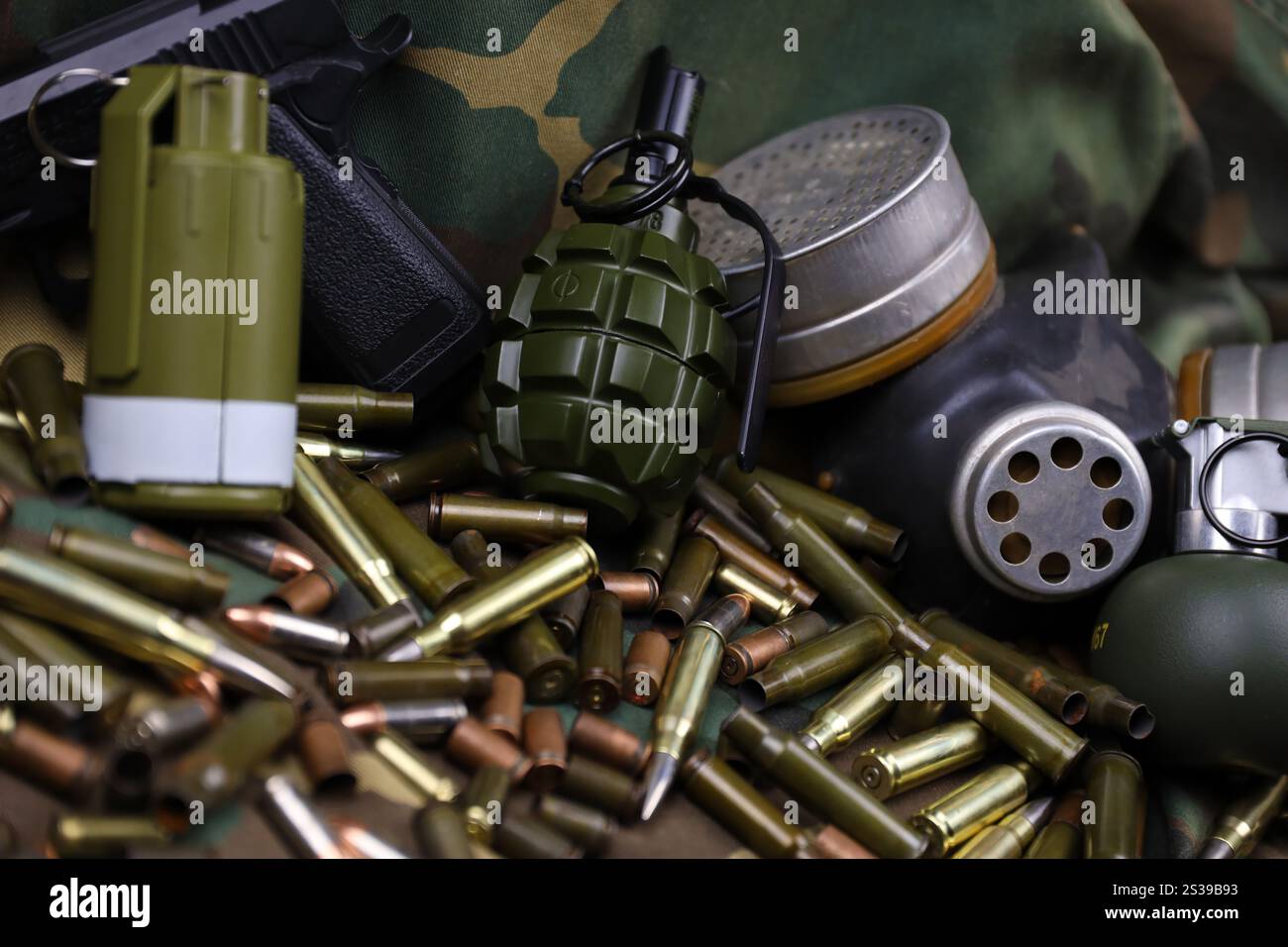 Différents types de munitions et de grenades sur un fond de camouflage ...