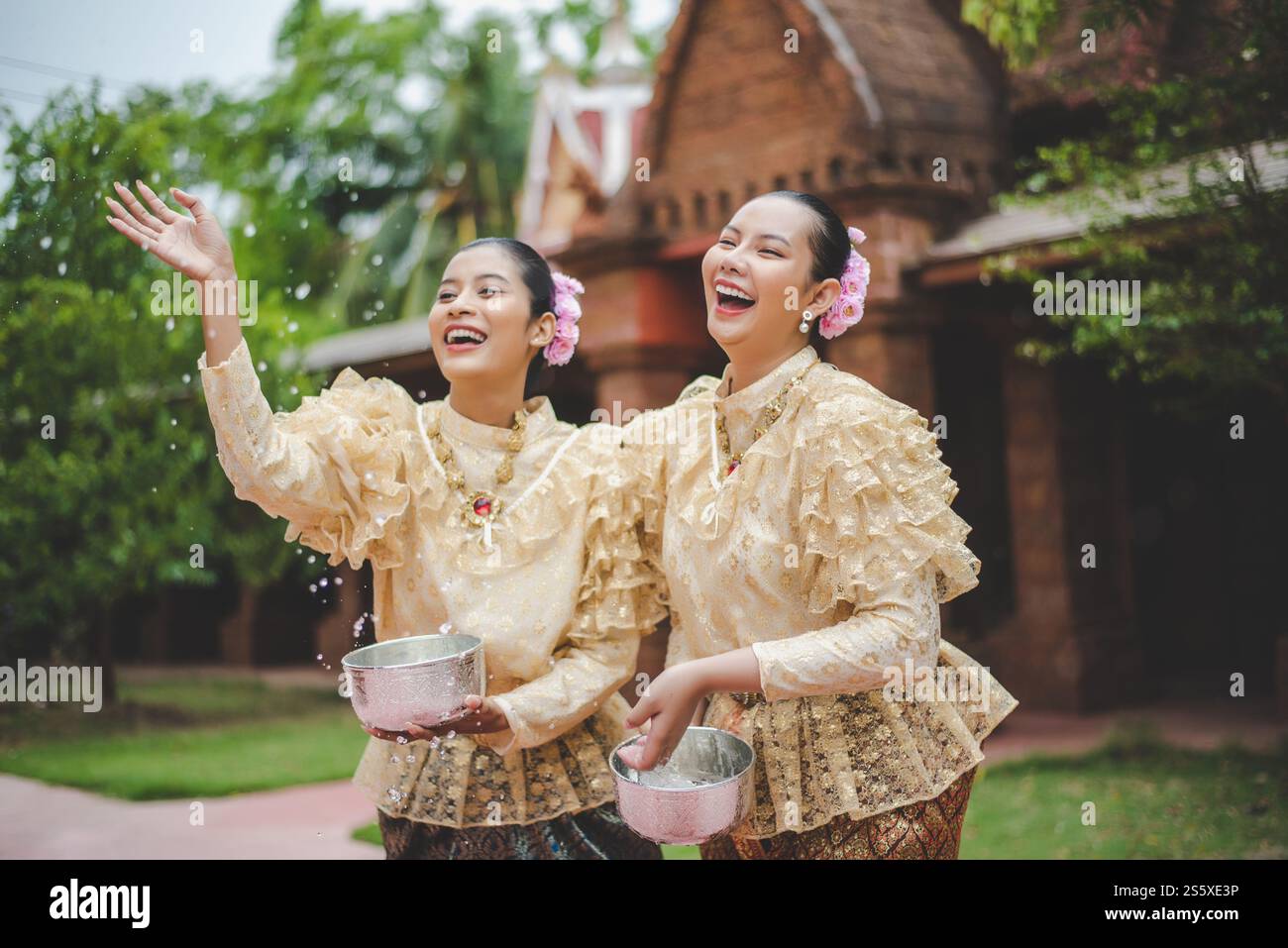 Les jeunes femmes souriantes s'habillent de beaux costumes thaïlandais ...