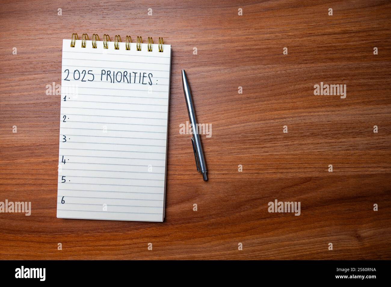 Bloc-notes avec texte 2025 priorités, sur surface en bois. Priorités et ...