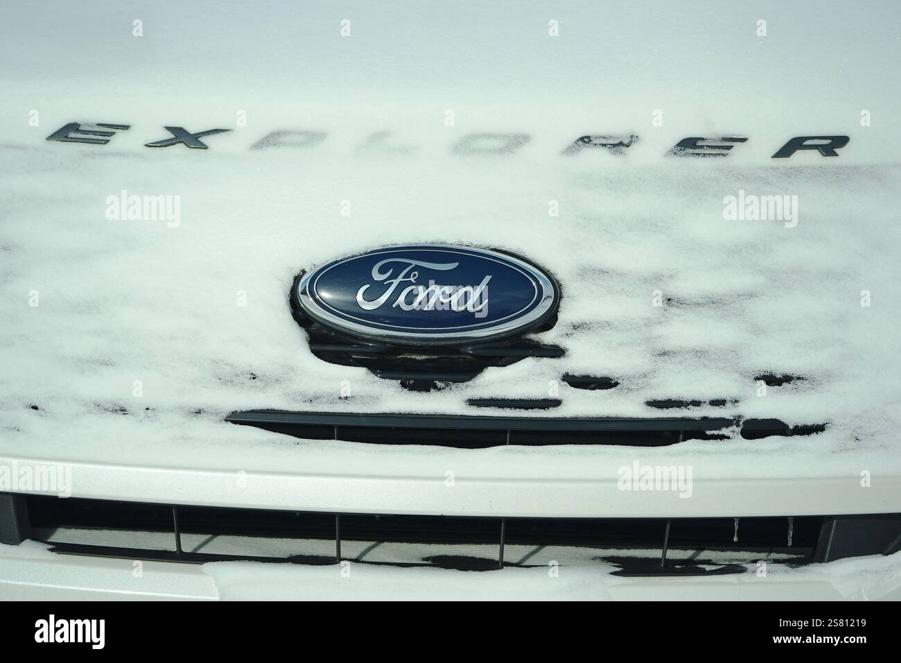 The blue oval sits on the grille of a snow-covered Ford Explorer ...