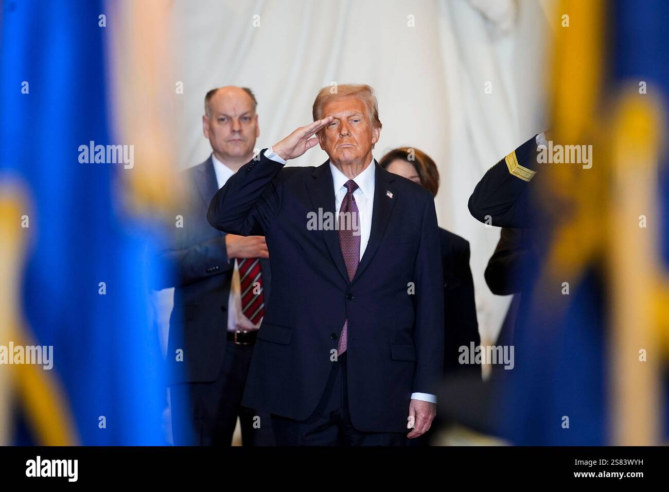 President Donald Trump salutes while on stage in Emancipation Hall at ...