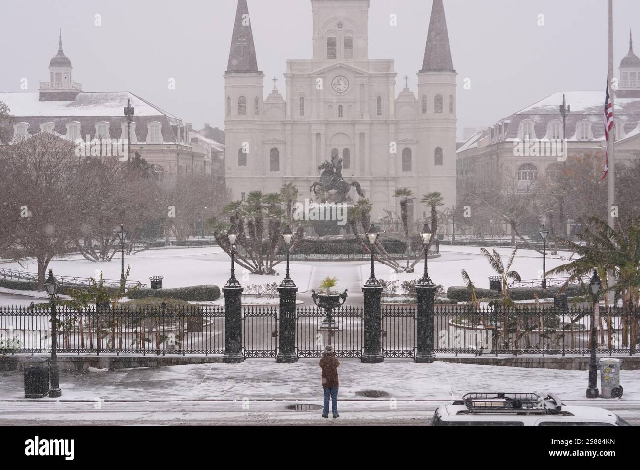 A person stops to take a picture at Jackson Square as snow falls in the French Quarter in New ...