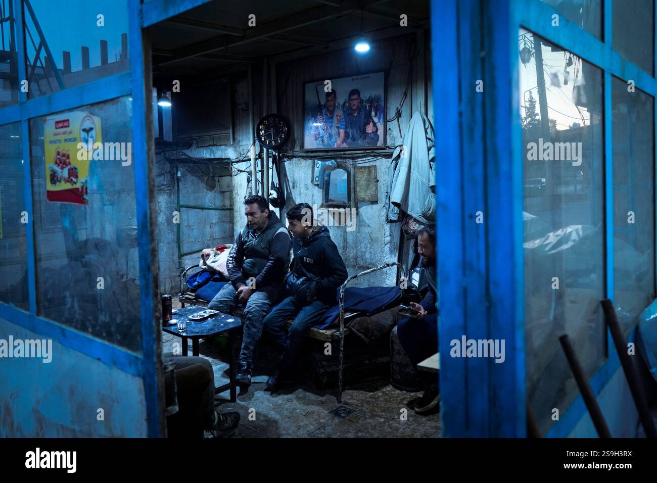 People sit inside the office of a petrol station in the northern Syrian ...