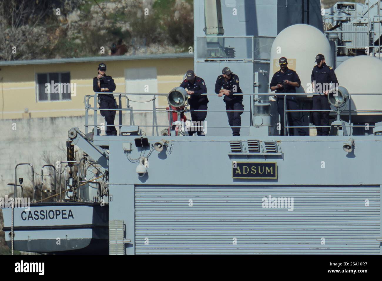 Crew members of the Italian Navy ship Cassiopea watch the ...