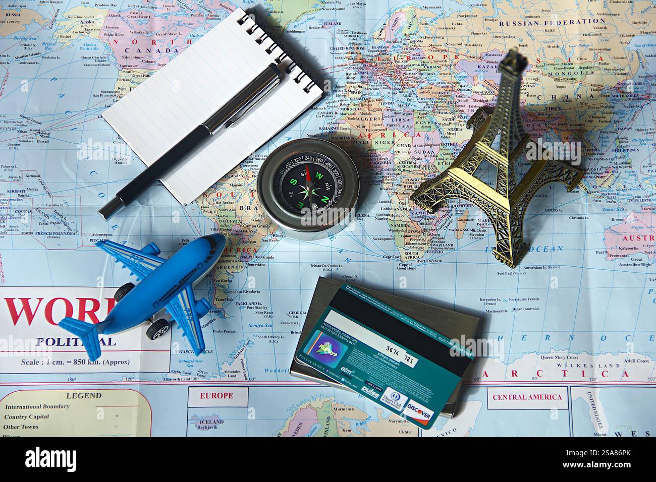 Prise de vue sur table avec un agenda, un stylo, un avion miniature et ...