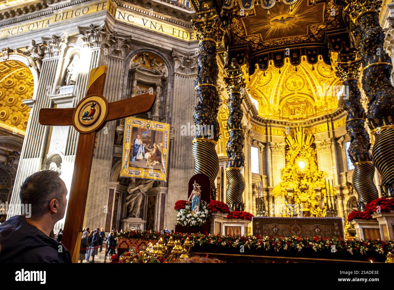 Pèlerin portant la croix du jubilé dans la basilique de Pierre pendant ...