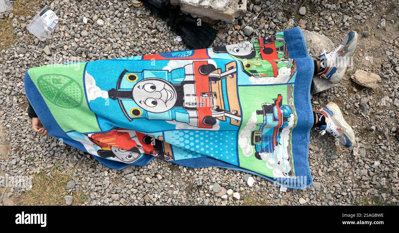 Couvert par Thomas the Tank Engine, un migrant dort le long de la voie ...