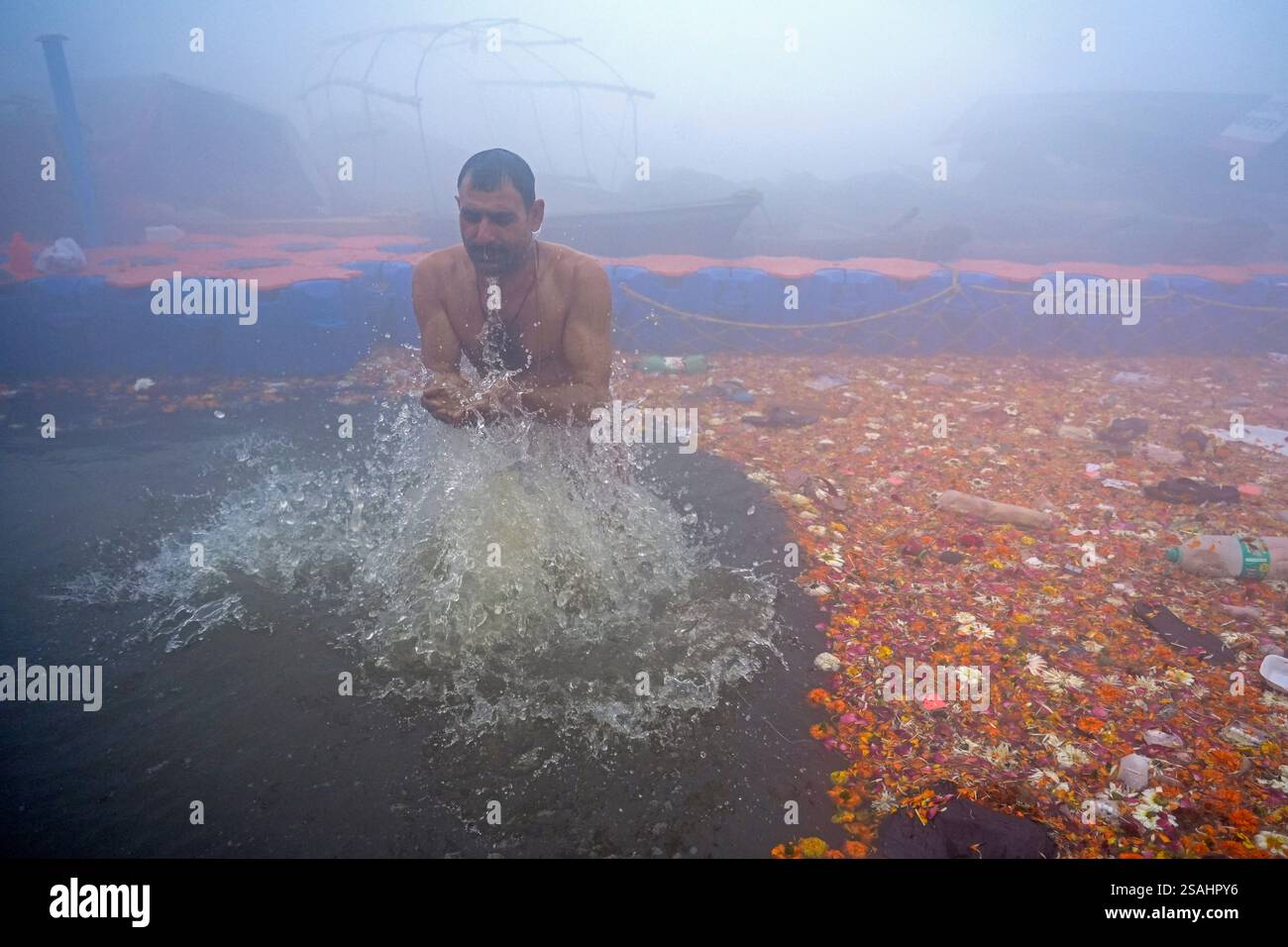 An Indian Hindu devotee takes a holy dip at Sangam, the confluence of ...