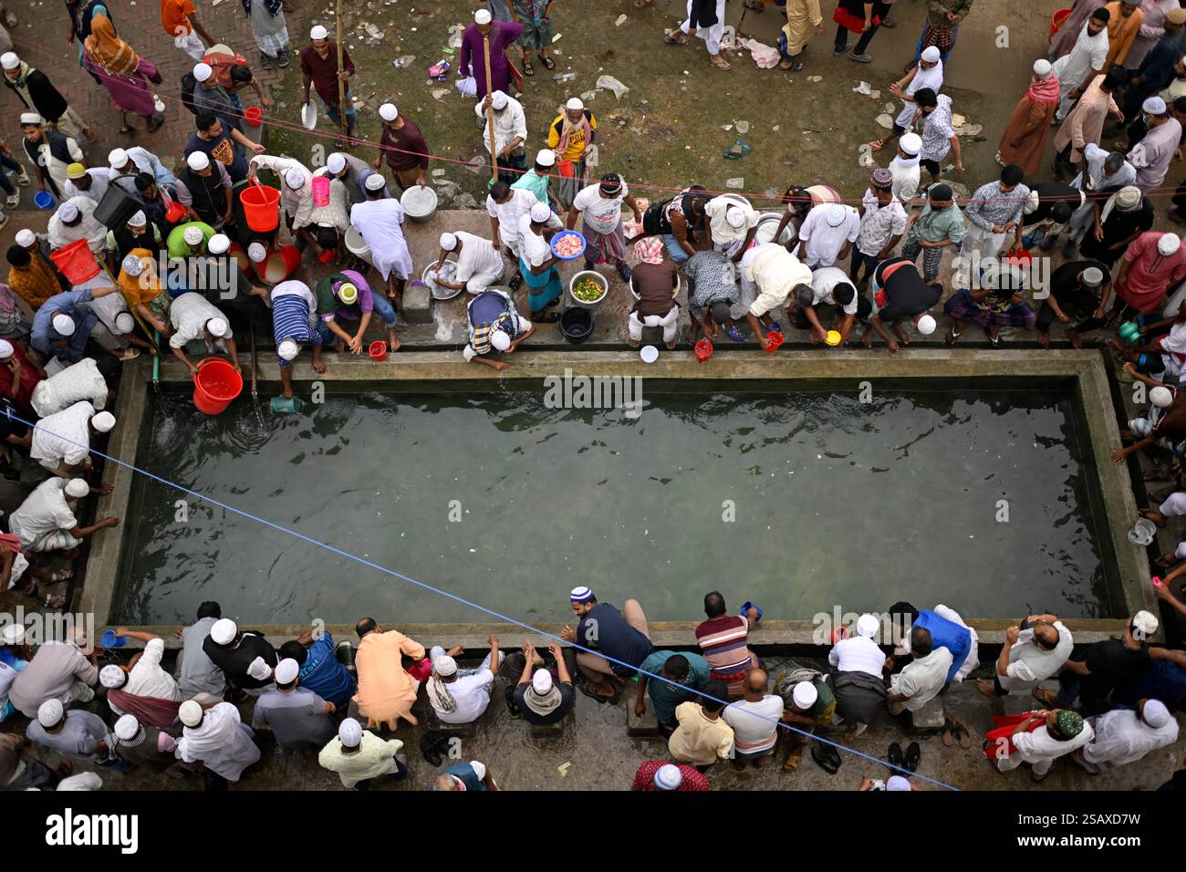 Muslim devotees perform ablutions before prayers during the first phase ...