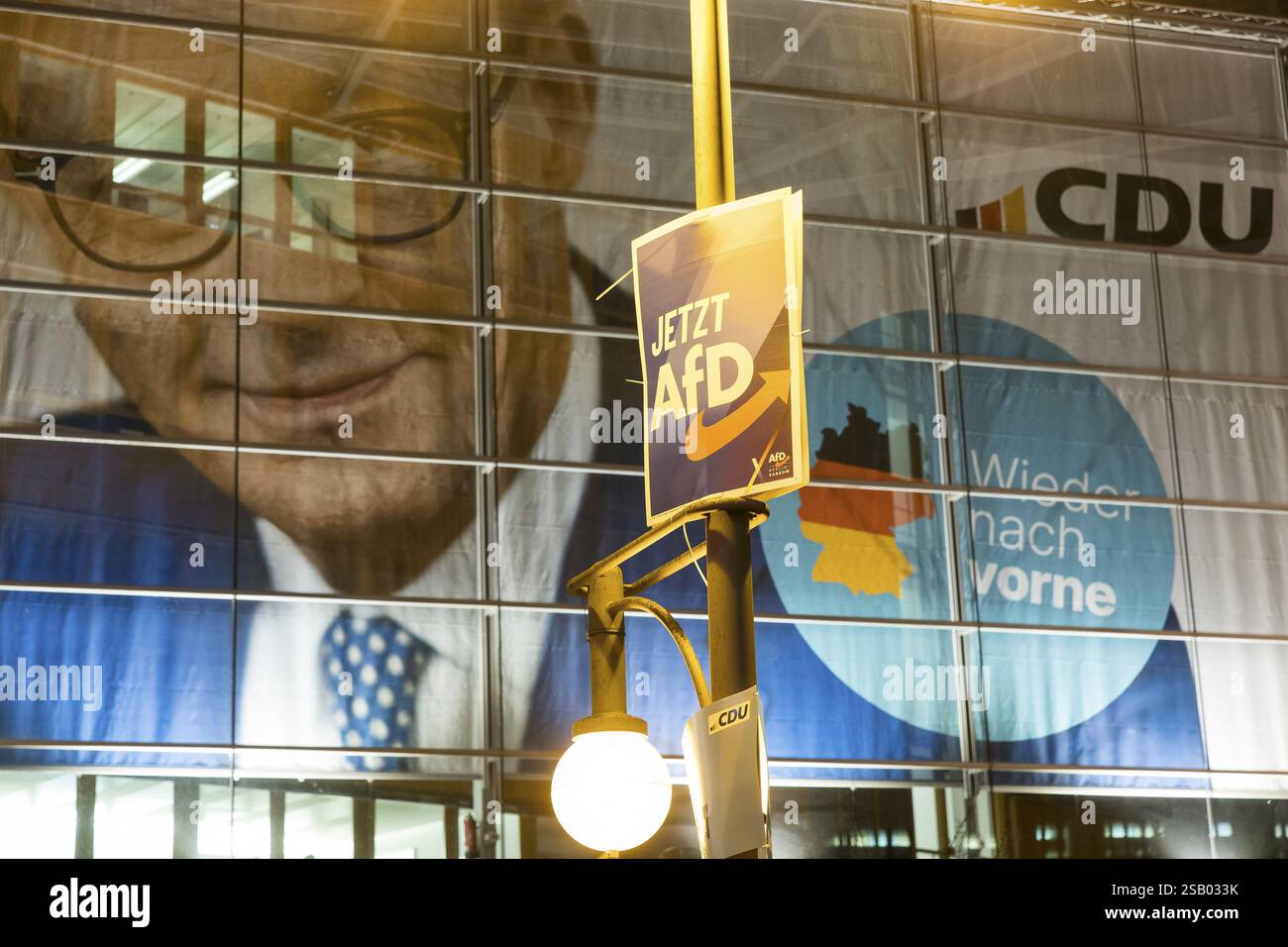 Bannière à l'image de Friedrich Merz derrière une affiche électorale de ...