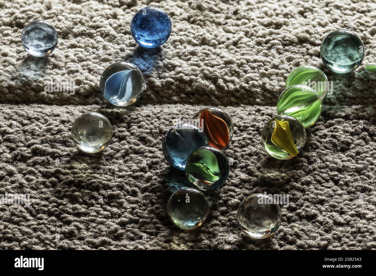assortiment varié de billes de verre colorées dispersées sur un tapis ...