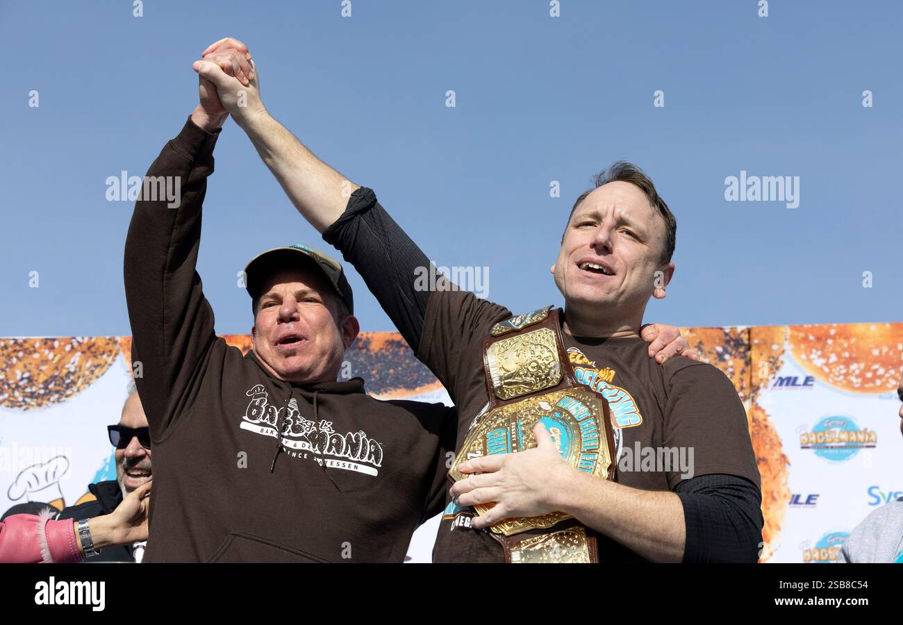 Joey Chestnut, right, has his arm raised by Stephen Siegel, CEO of ...