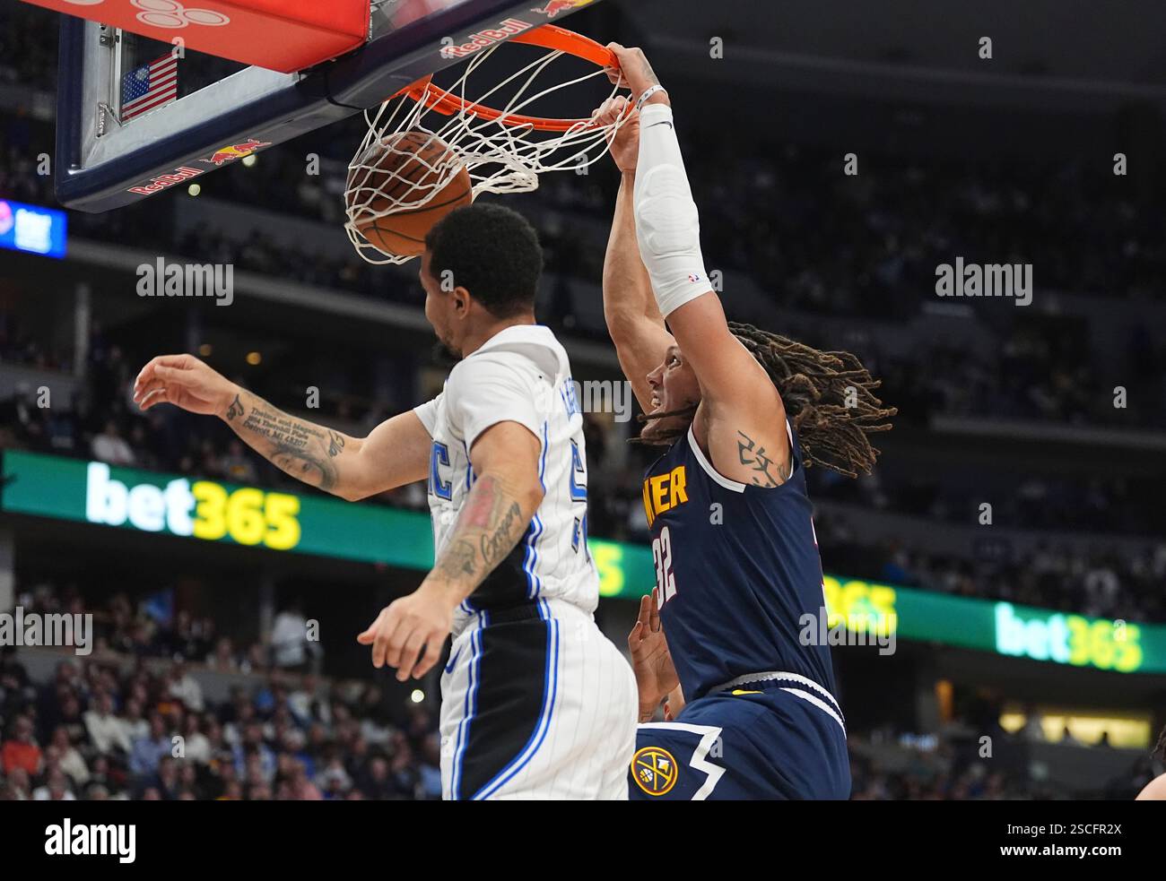 Denver Nuggets forward Aaron Gordon, right, hangs from the rim after ...